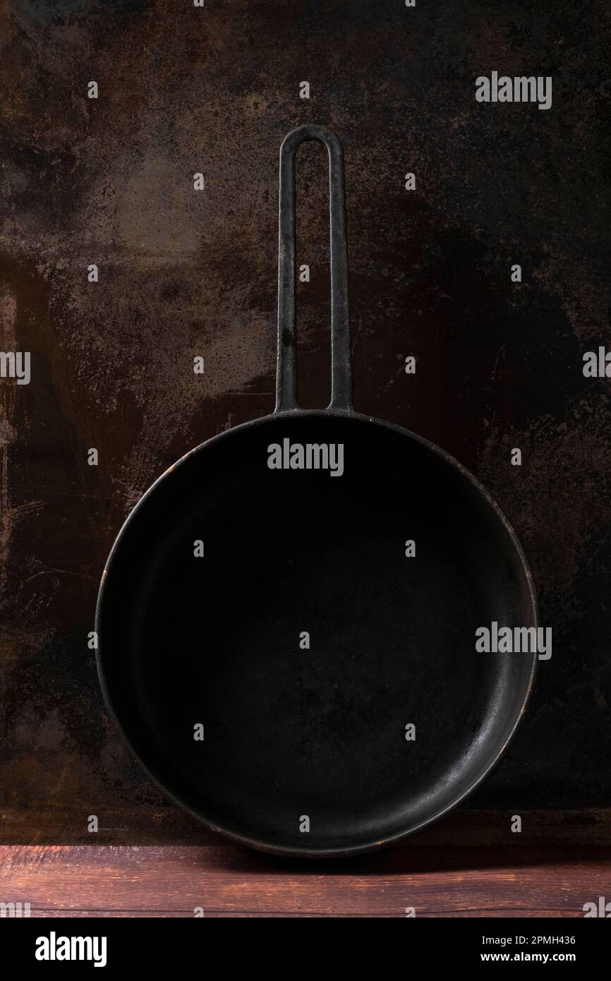Black iron cast pan on dark background Stock Photo - Alamy