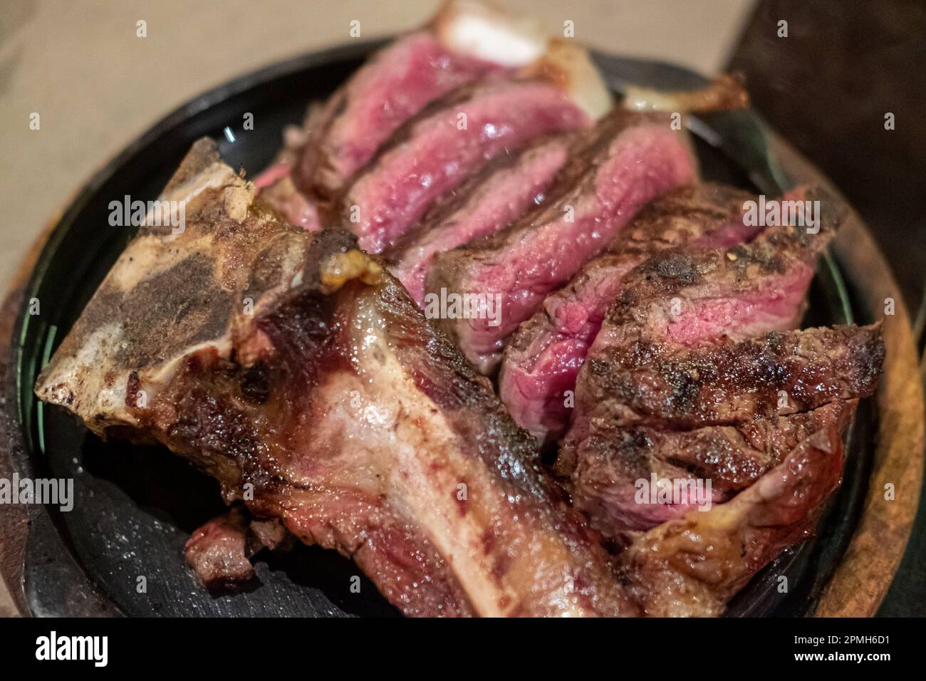 Medium rare Tomahawk meat on plate Stock Photo - Alamy