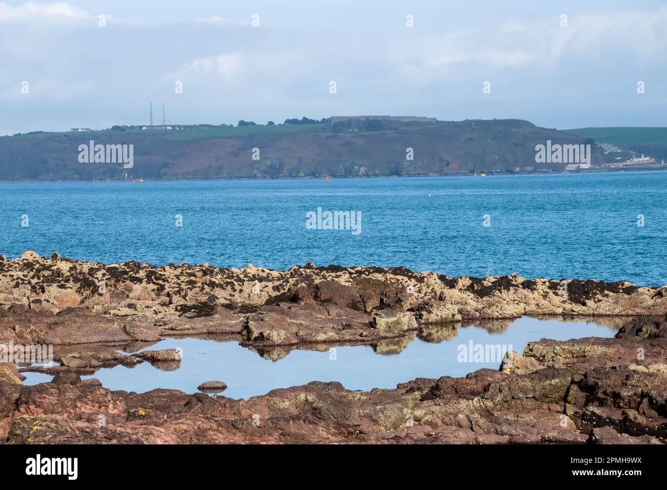 rockpool on a rocky Cornish beach with the sea and Plymouth Sound in ...