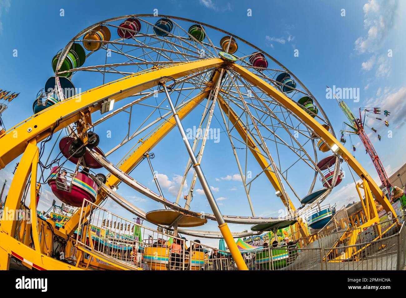 Fisheye lens shows low-angle view of massive carnival ferris wheel in ...