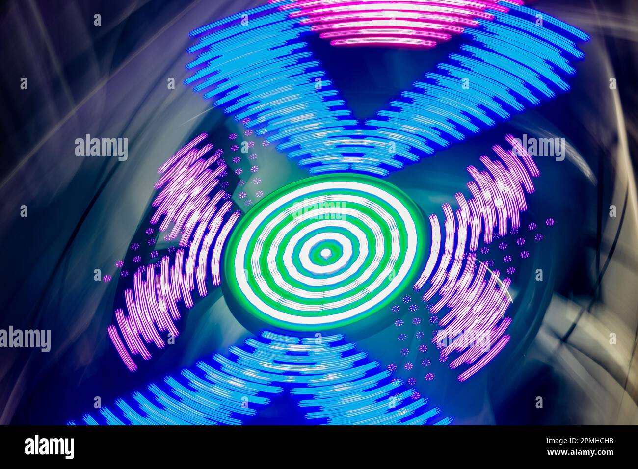 The colorful lights of a fast moving carnival ride motion blur to form ...