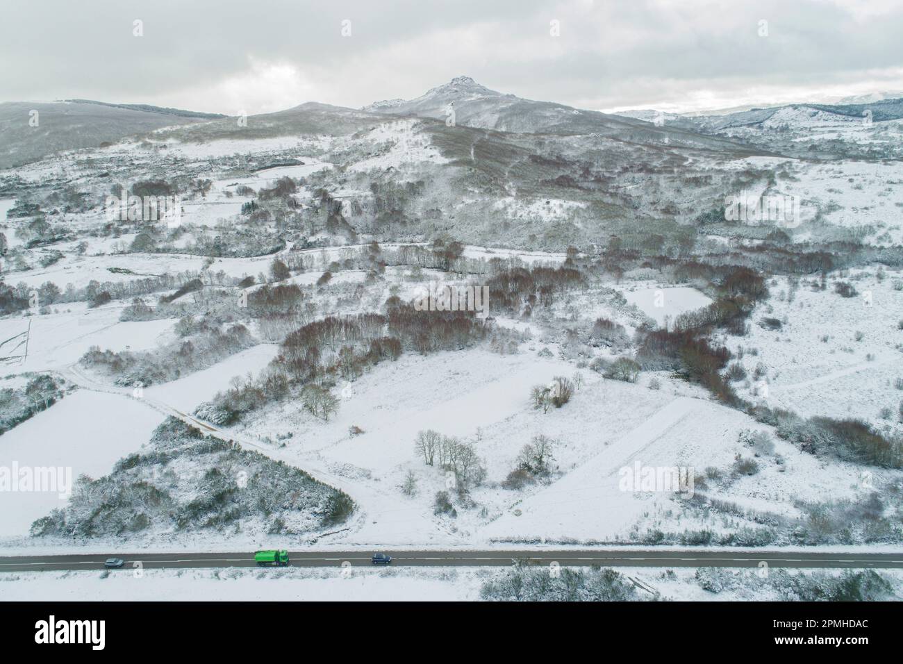 drone aerial view of three vehicles in a road in a snowy landscape ...