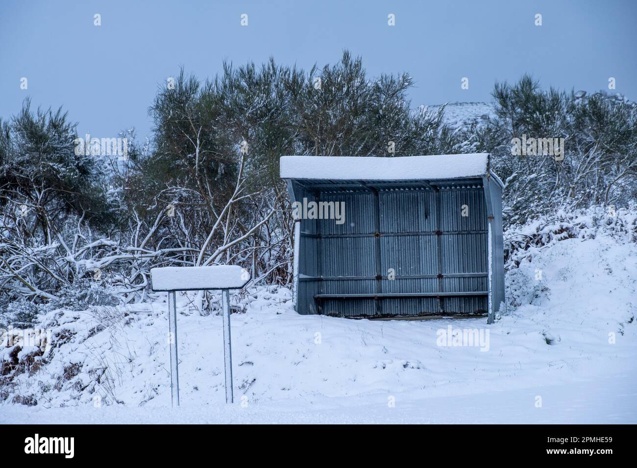 Snowy landscape in southern Galicia. Bus stop and sign covered with ...