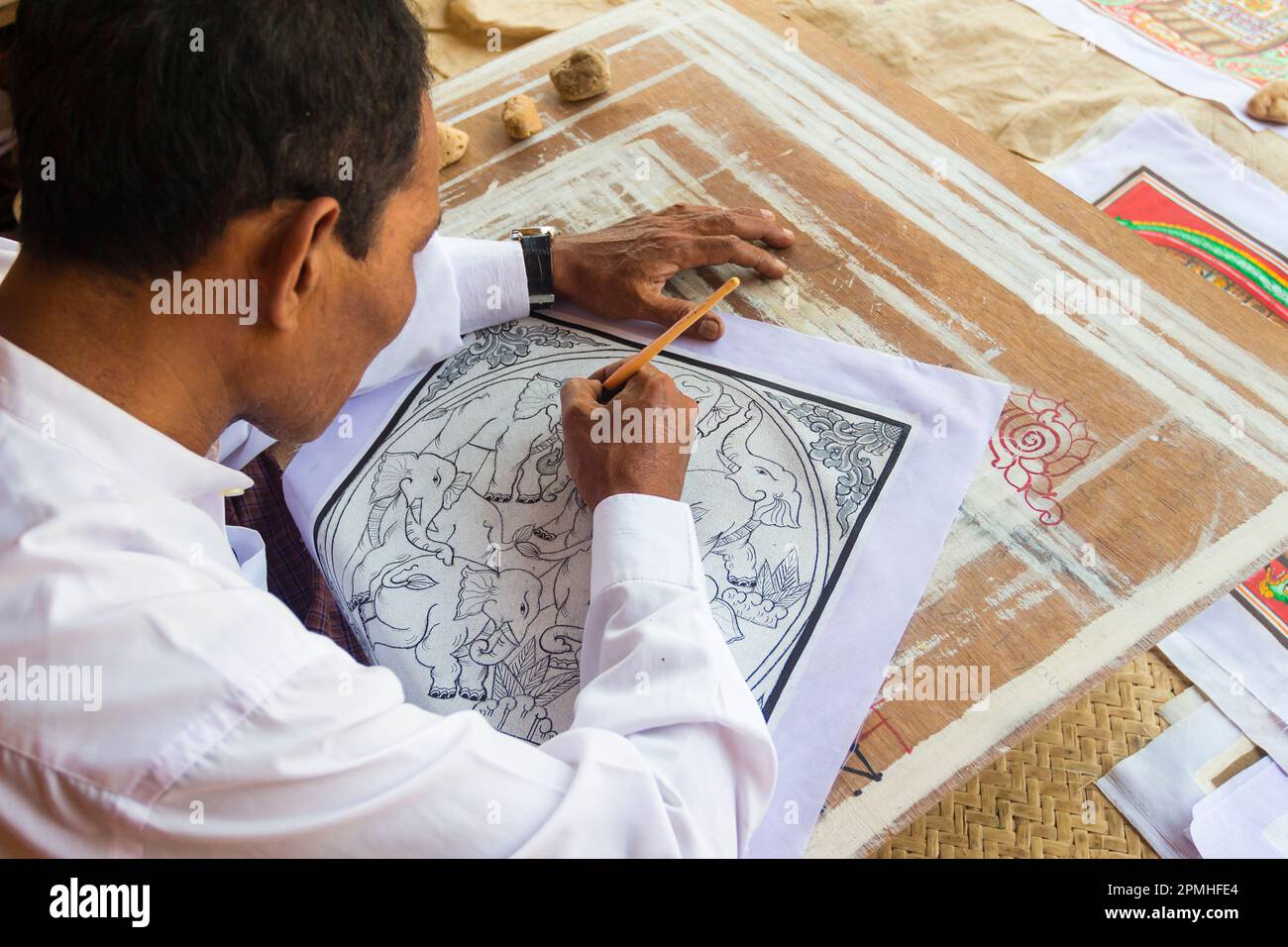 Artist drawing design featuring elephants on canvas, Bagan, Myanmar ...