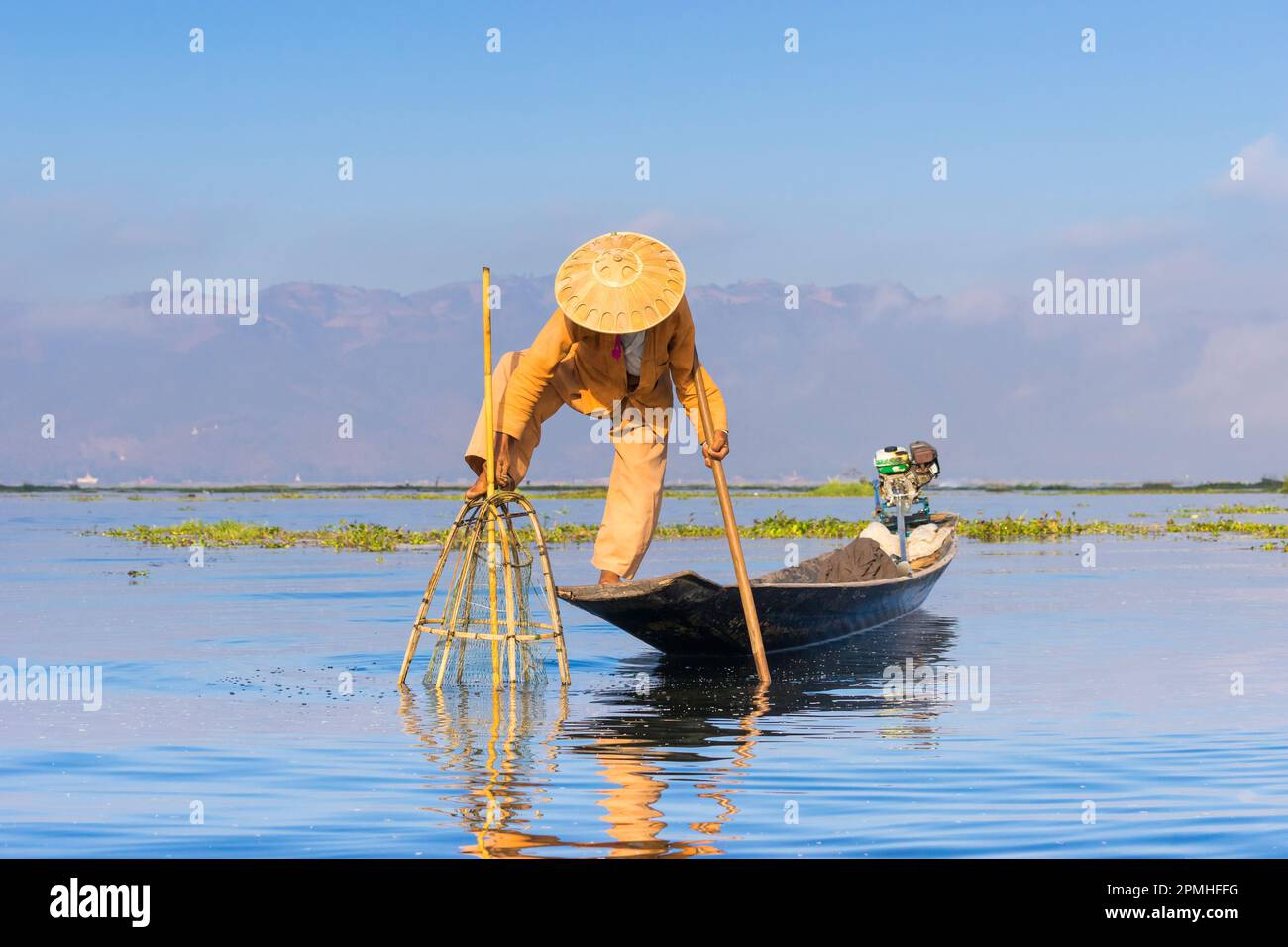 Fisherman with traditional conical net on boat, Lake Inle, Shan State ...