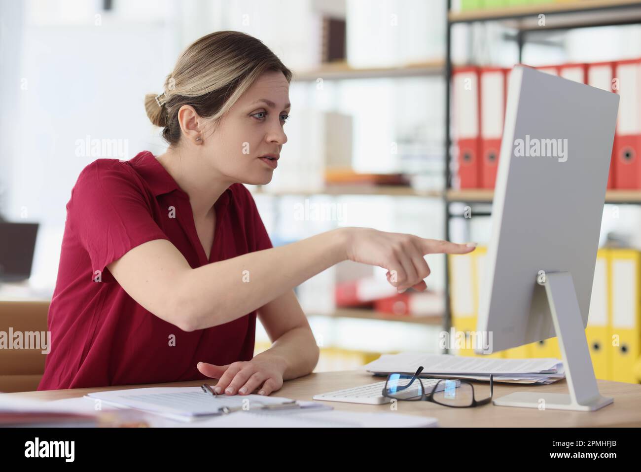 Suspicious woman points finger to screen of computer monitor Stock ...