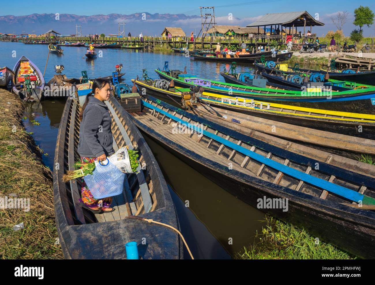 Woman returning to boat after shopping, boat harbor, Lake Inle, Shan ...