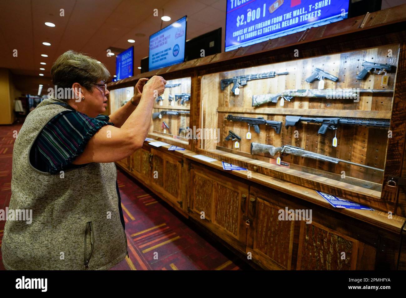 Trudy Jackson takes a photo of a display of guns in the Indiana ...
