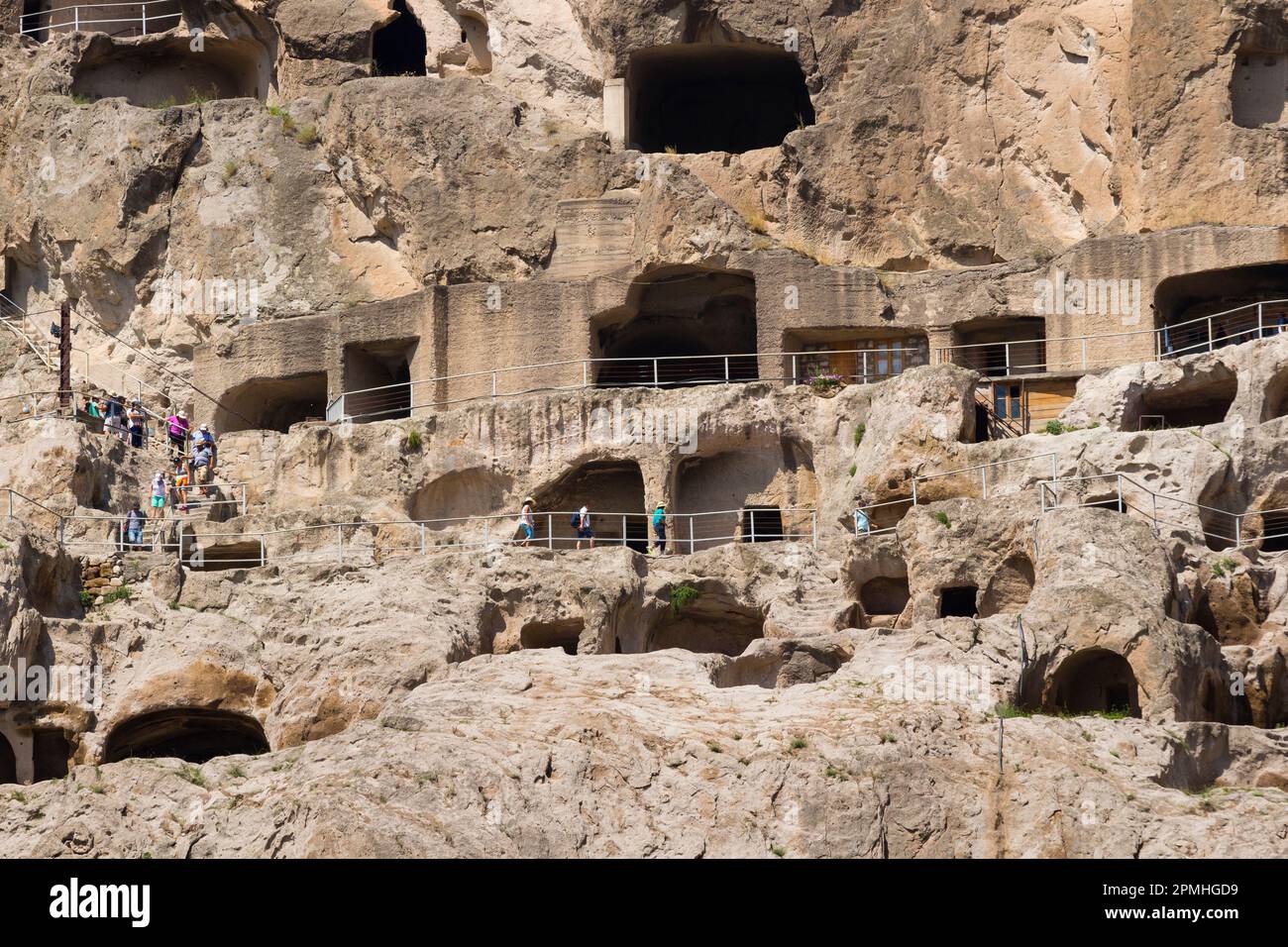 Tourists exploring ancient cave city of Vardzia, Georgia, Central Asia ...