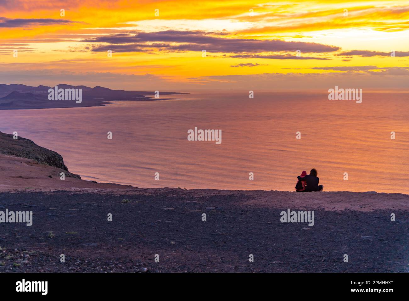 View of couple overlooking volcanic coastline from Mirador del Rio at ...