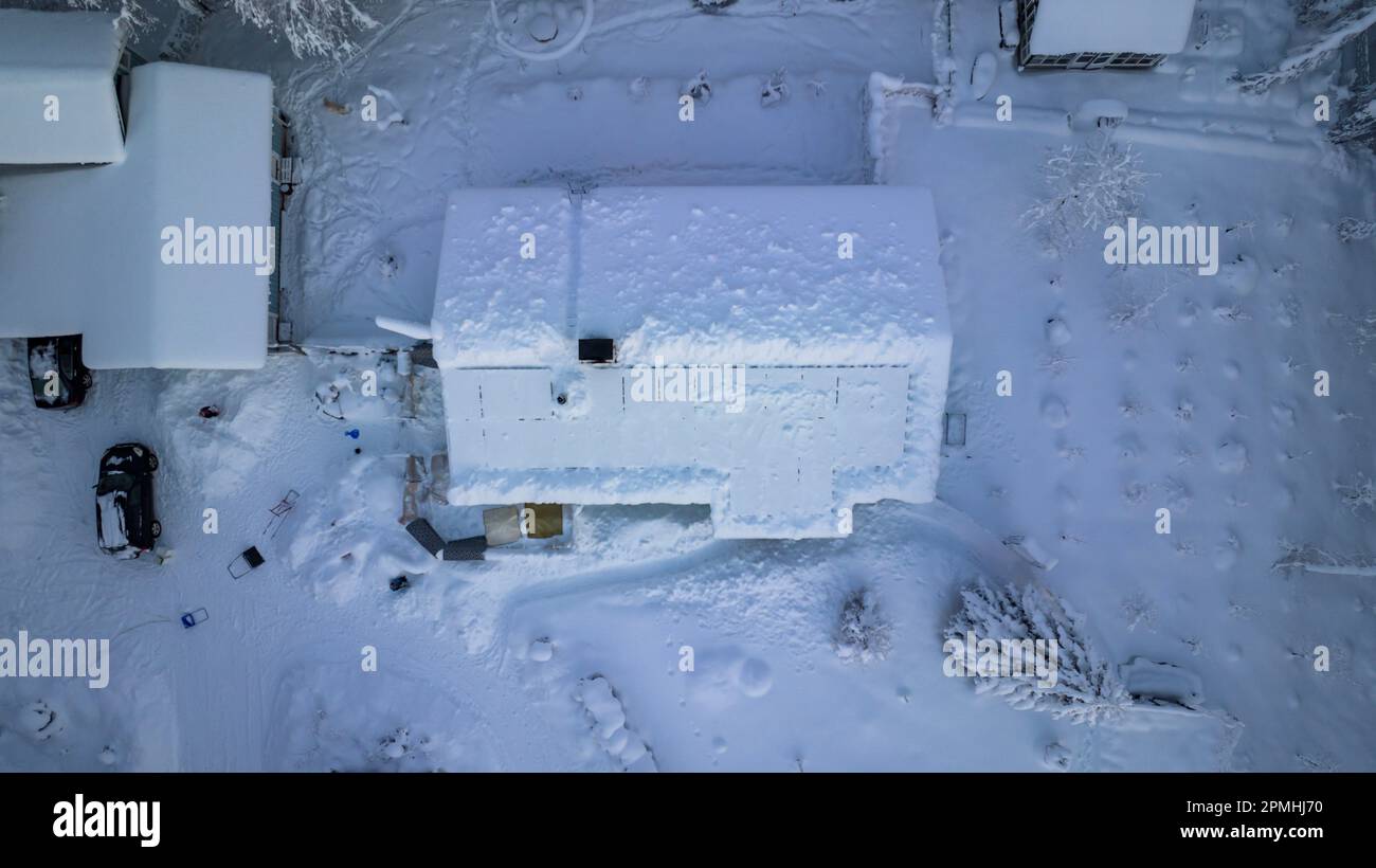 Aerial view above a snowy house with photovoltaic panels - top down ...