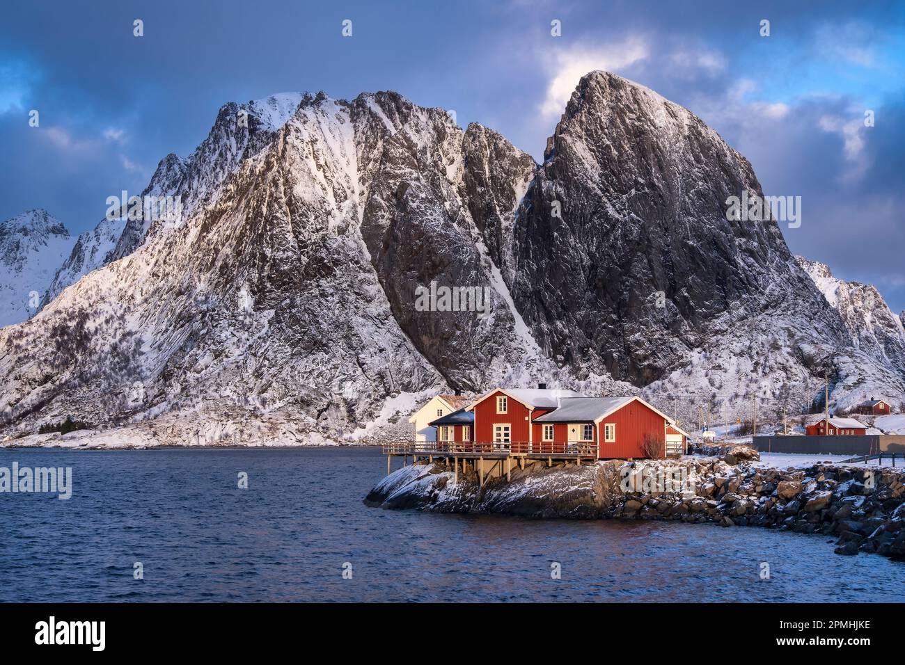 Red Norwegian Rorbuer Cabins and Festhaeltinden mountain in winter ...