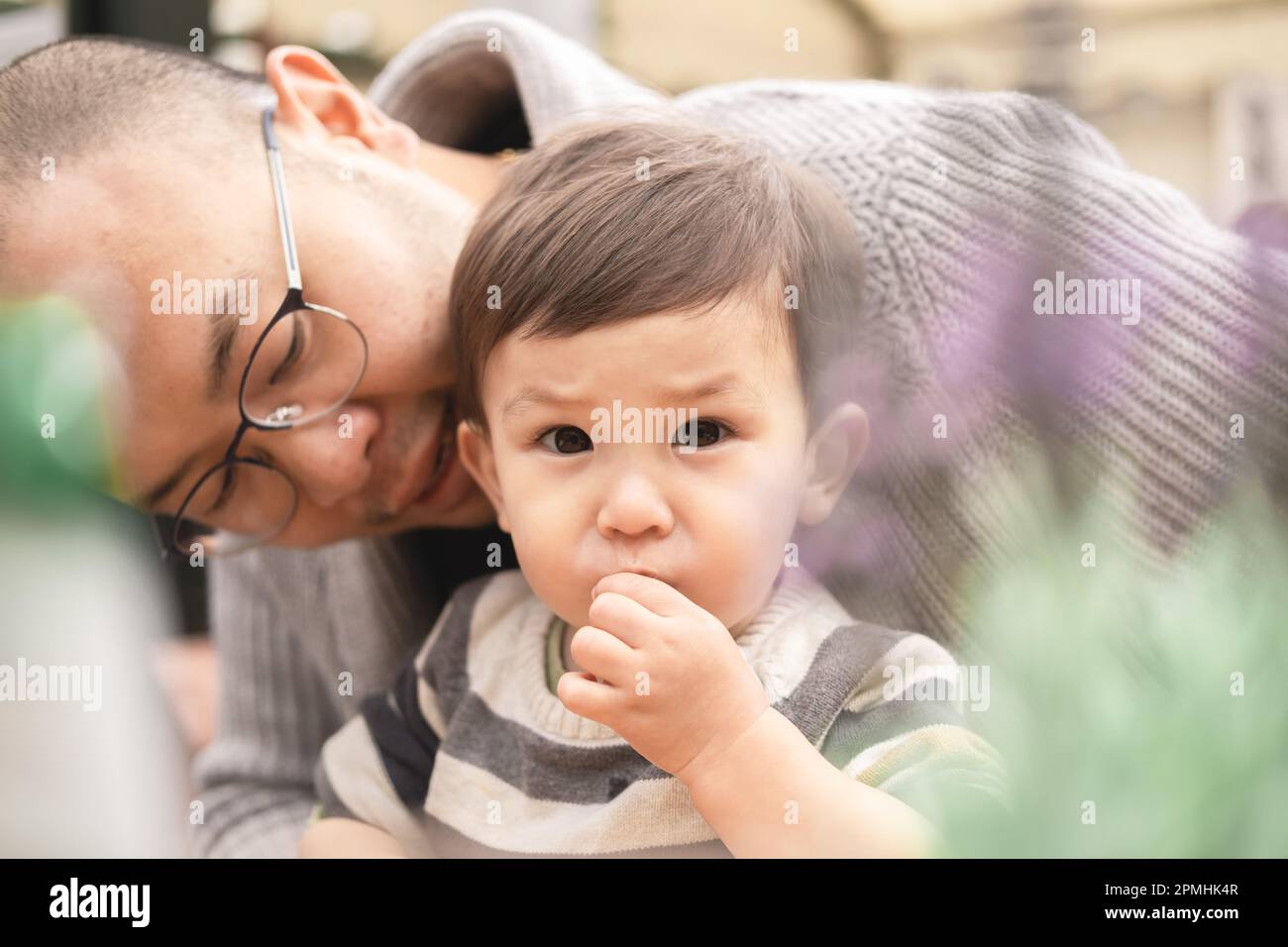 Dreamy picture of male infant staring looking at camera sitting on his ...