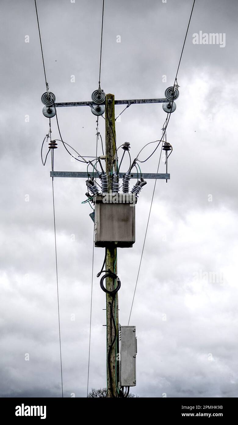An electric power transformer mounted on wooden poles in the UK ...