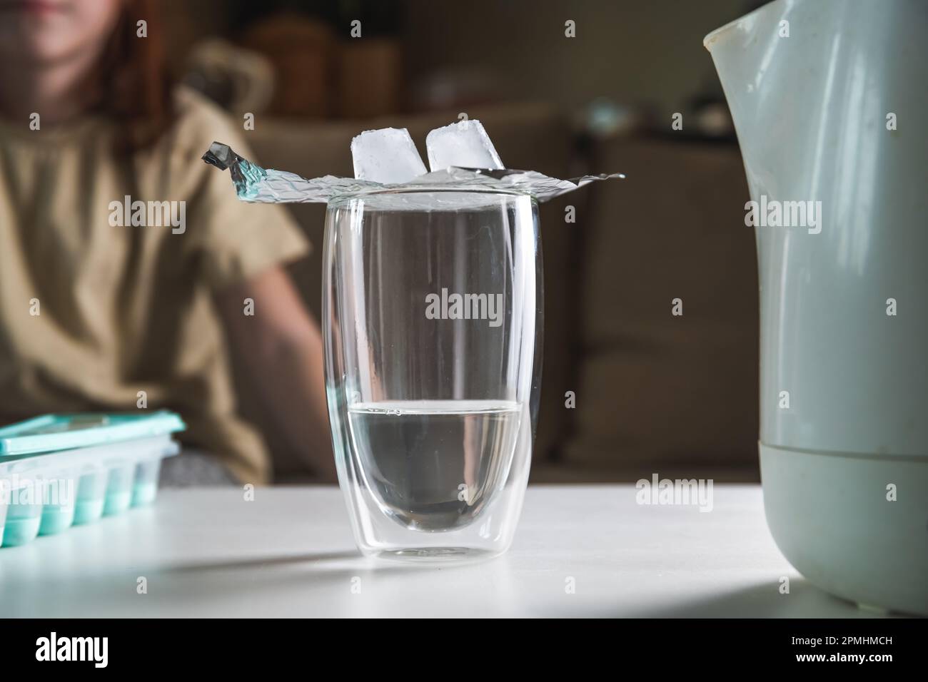 a schoolgirl conducts an experiment with hot water and ice. experience ...