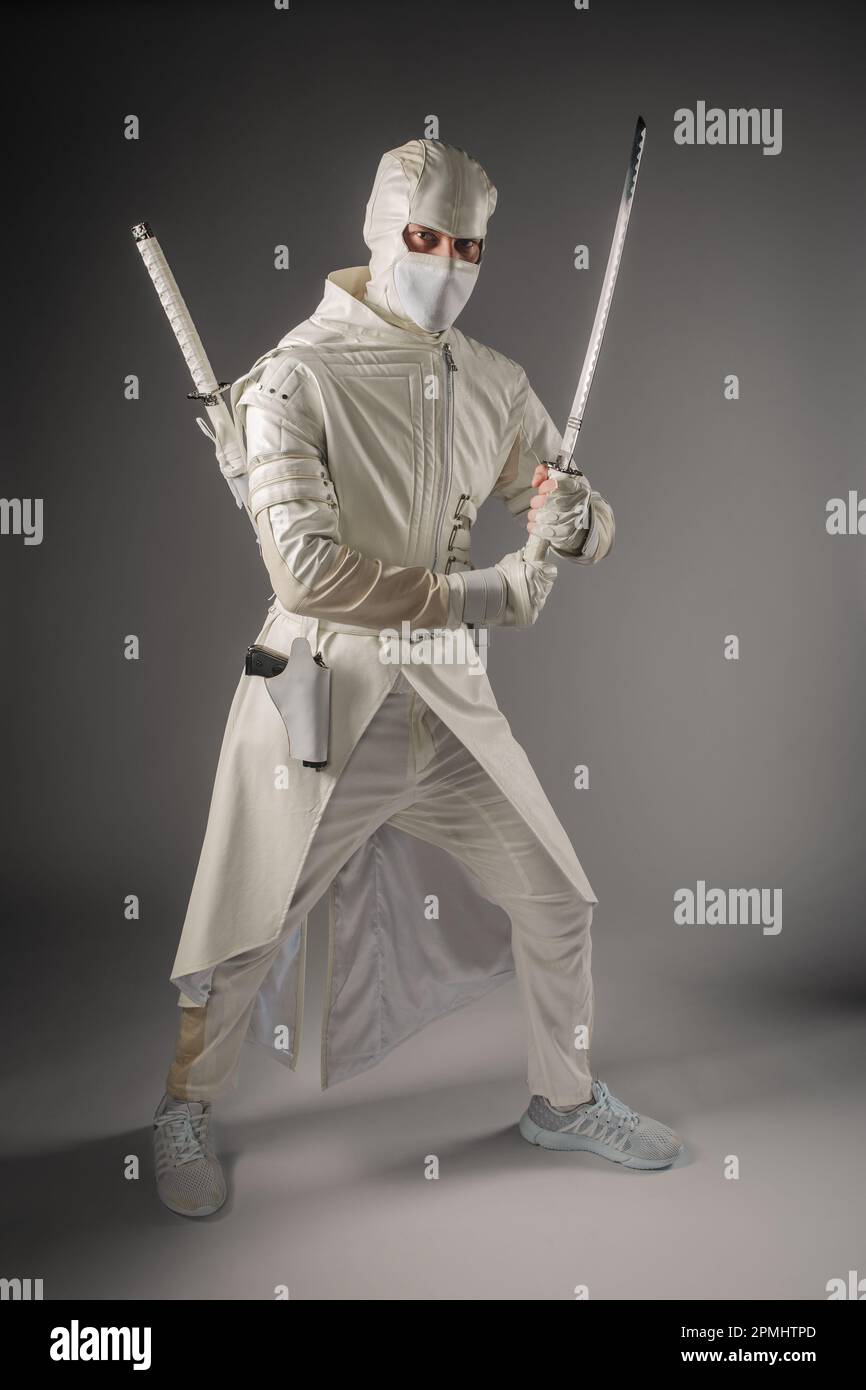 Ninja poses for a photo on a gray background, a male ninja in a white ...