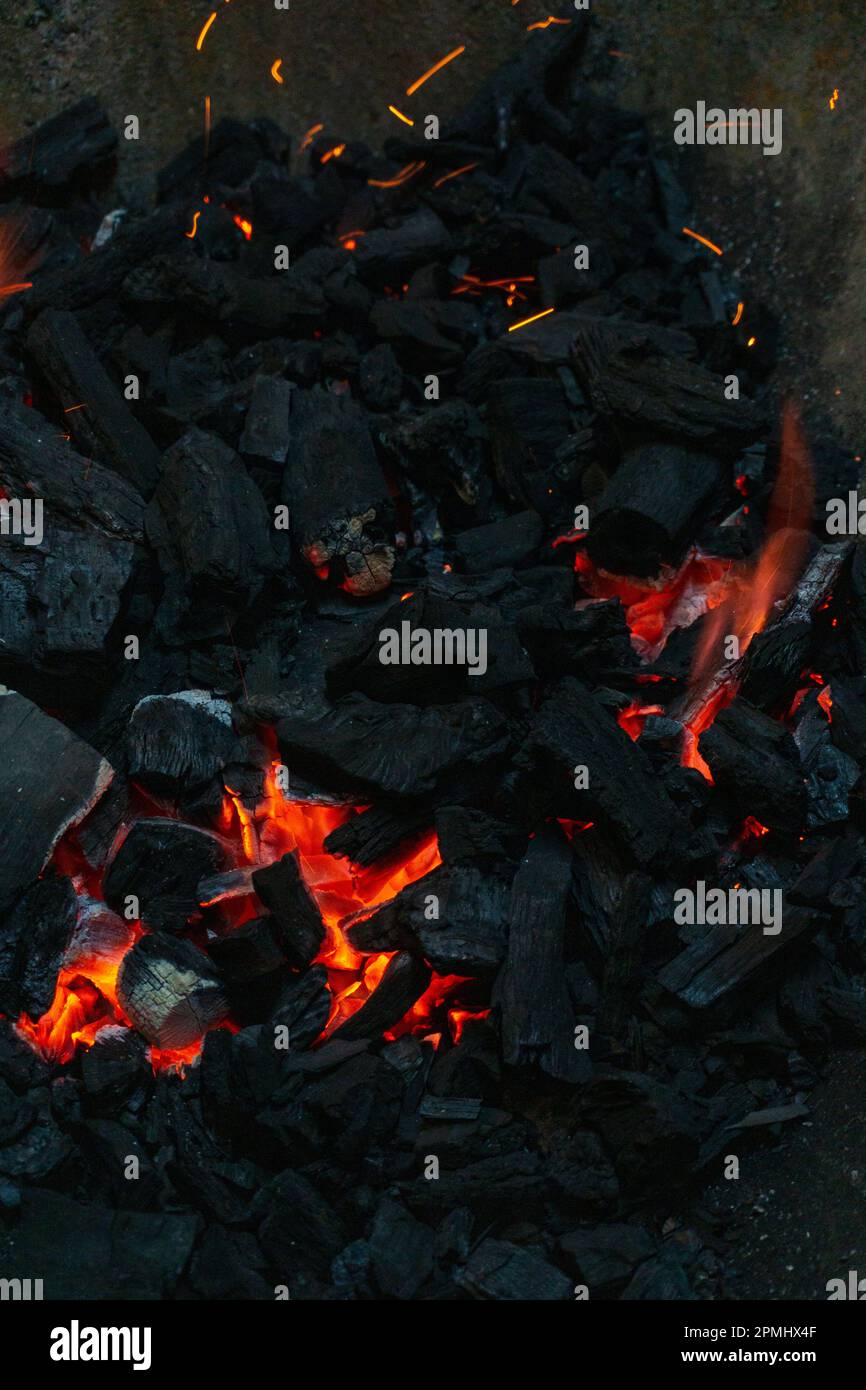 Coals with sparks in a huge old metal grill background Stock Photo - Alamy
