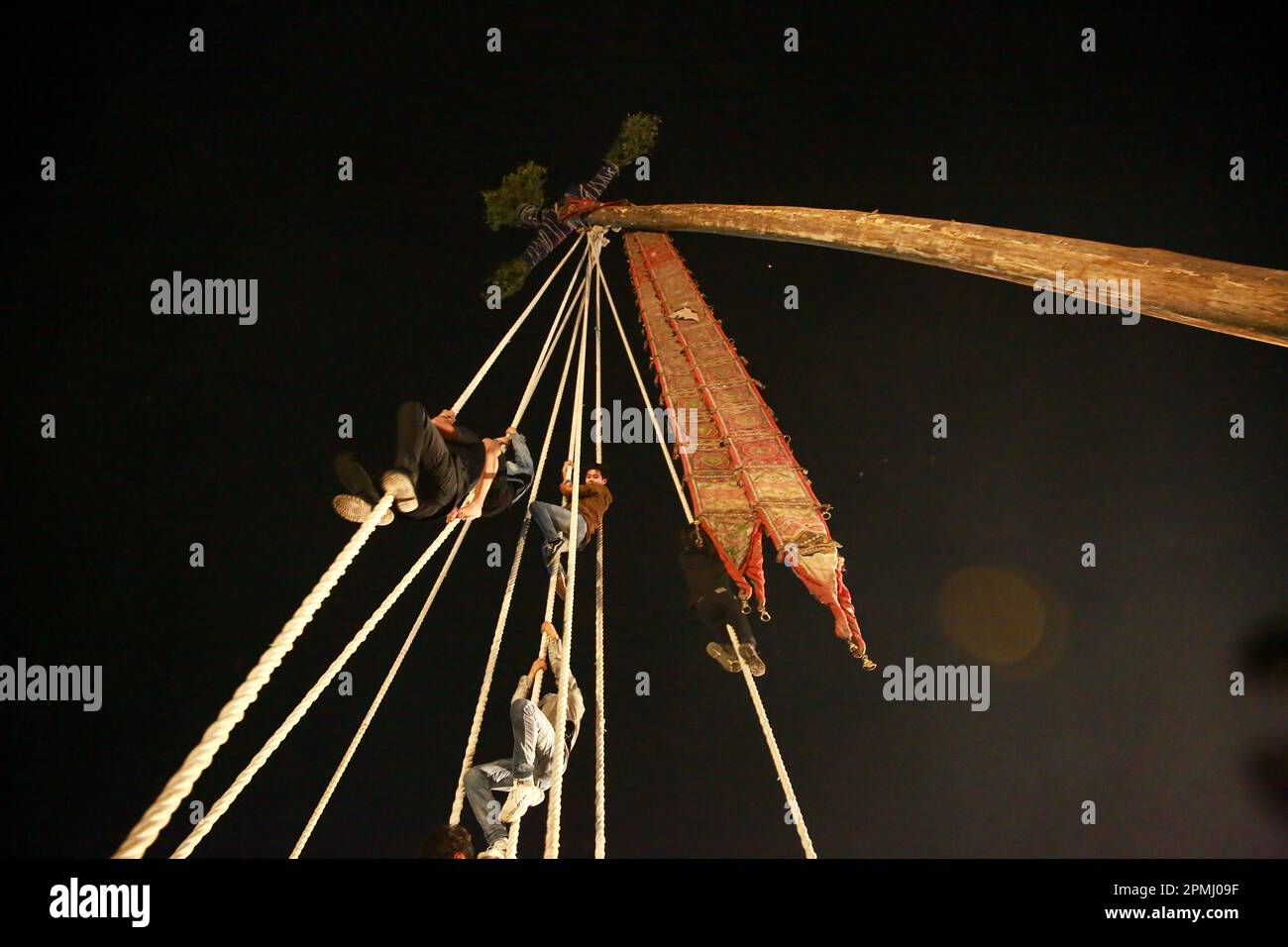 Nepal. 13th Apr, 2023. Devotees climb on a long ceremonial pole called ...