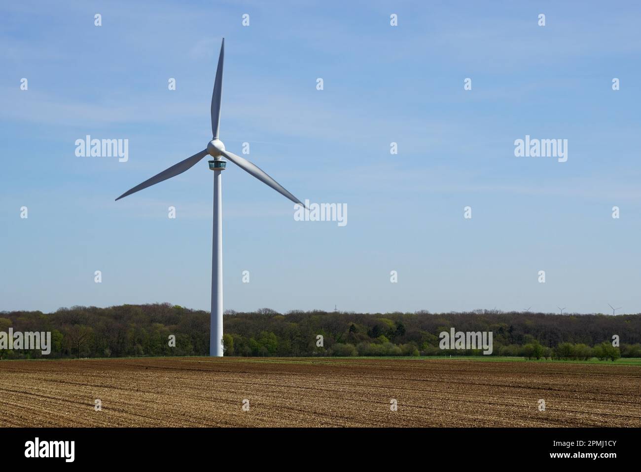 solitary three-bladed wind turbine on a field Stock Photo - Alamy