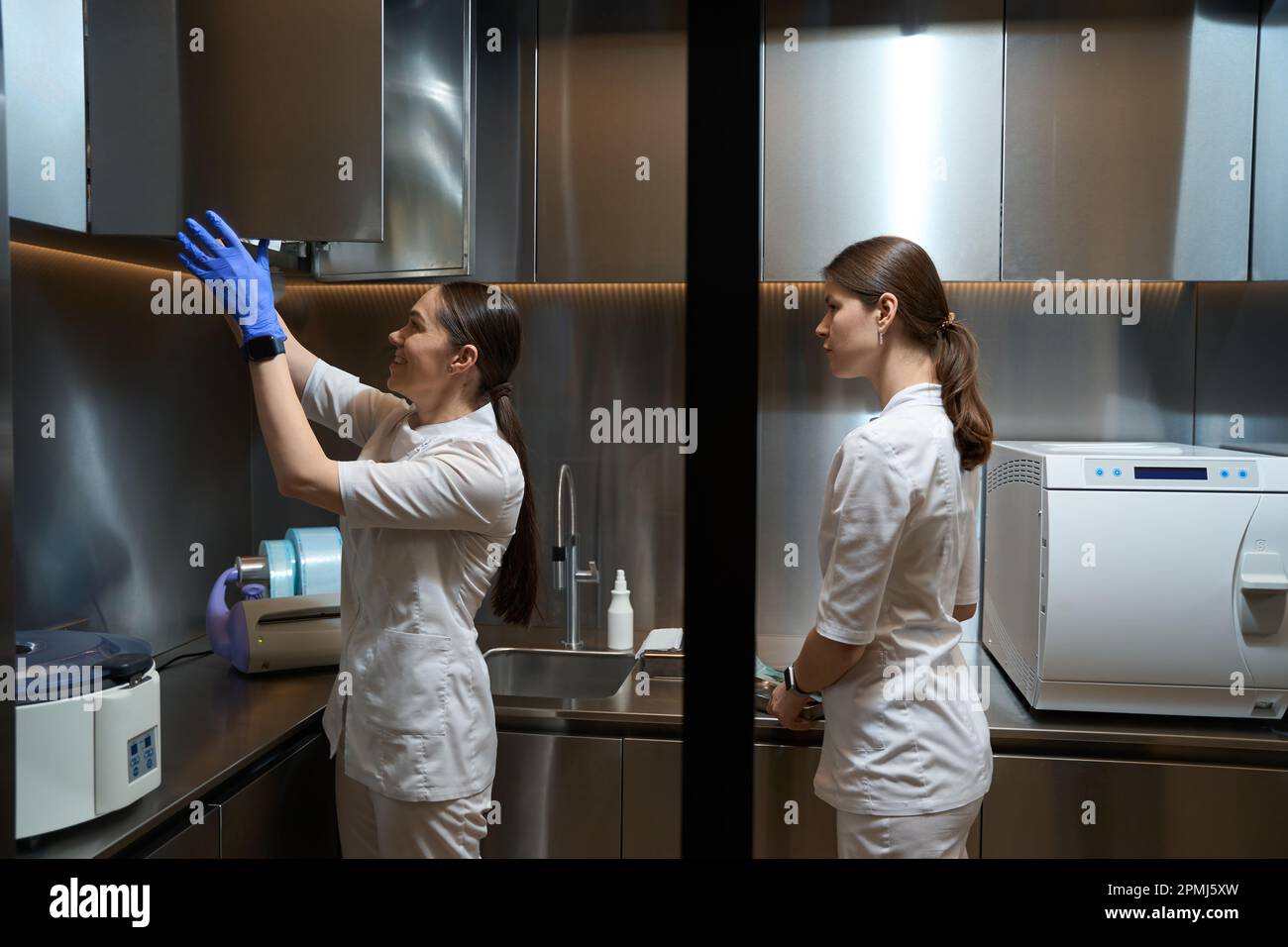Female medical assistants are standing and working in a laboratory room ...
