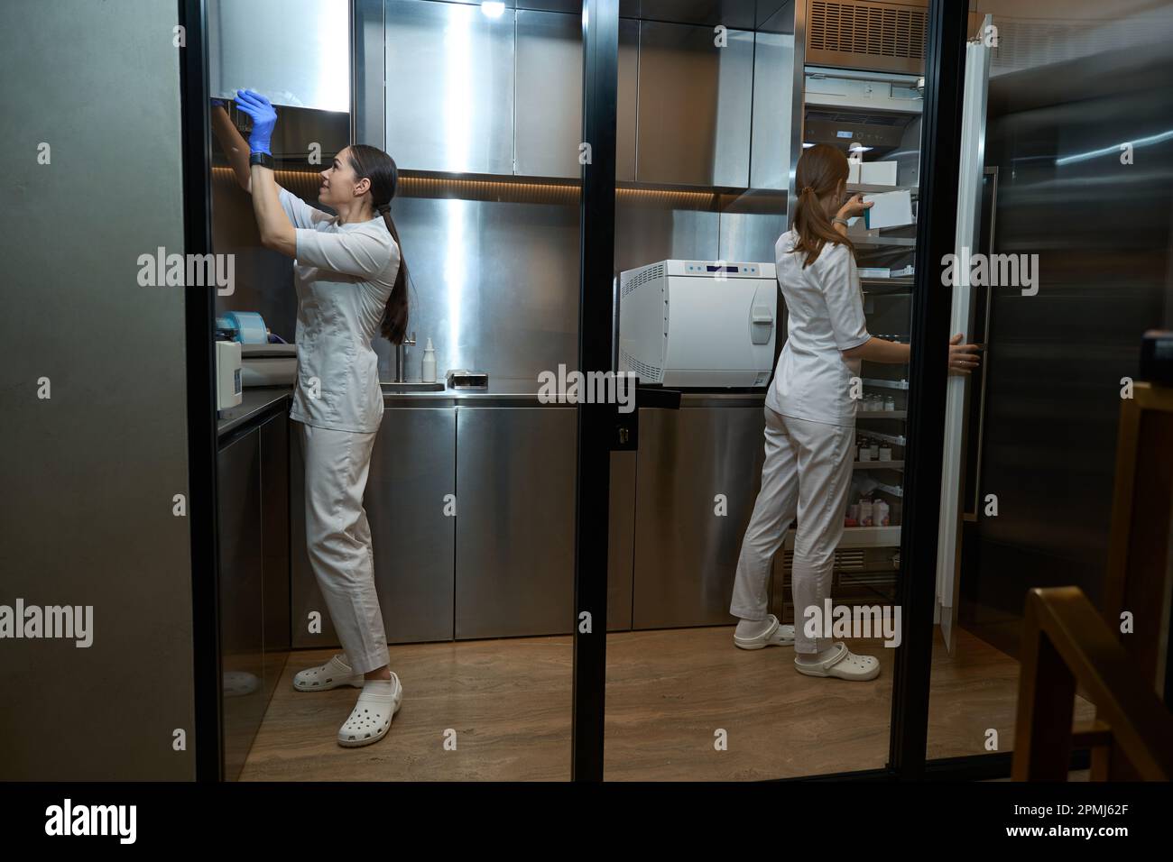 Female medical assistants are standing and working in a laboratory room ...