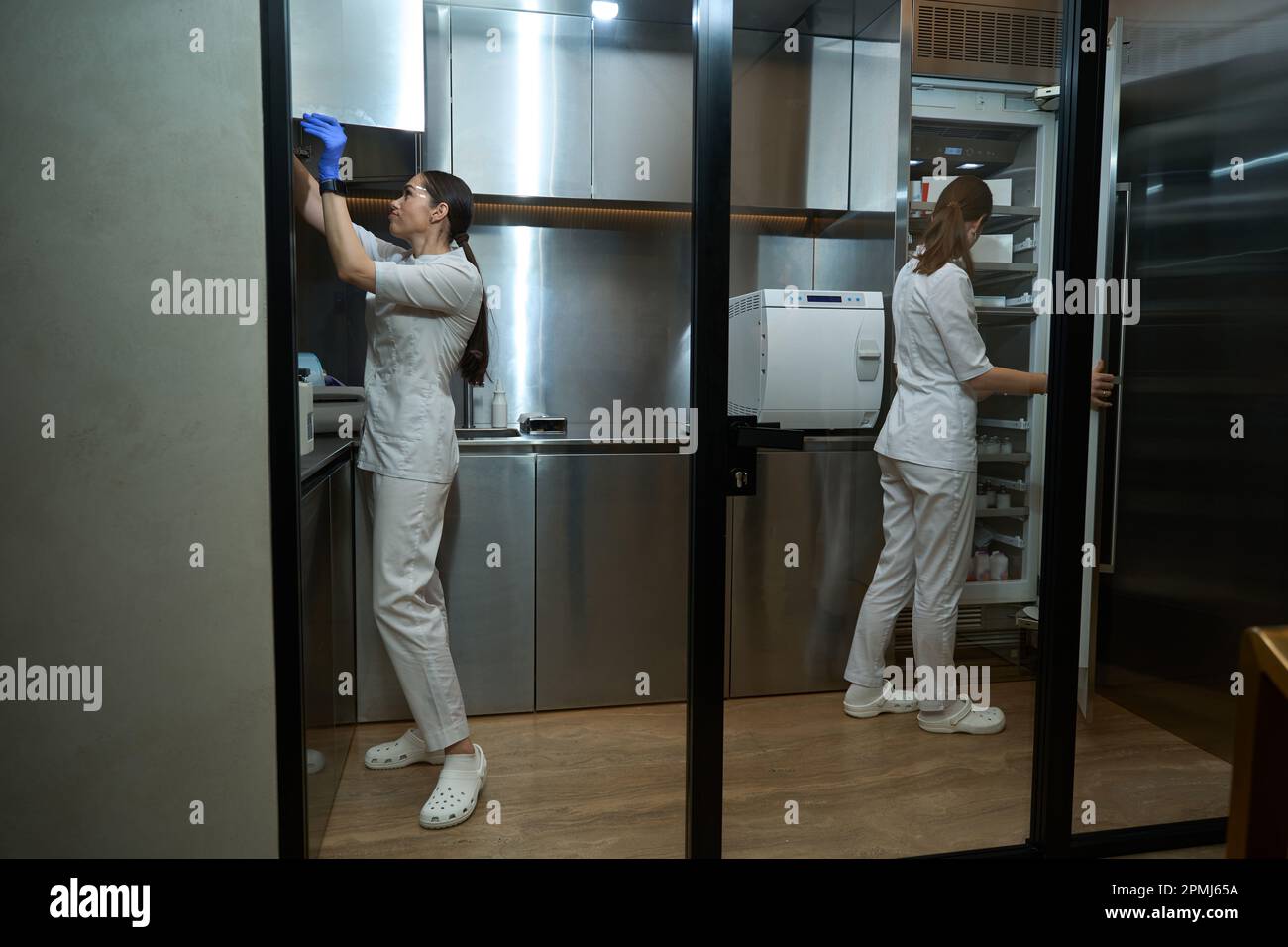 Female medical assistants are standing and working in a laboratory room ...