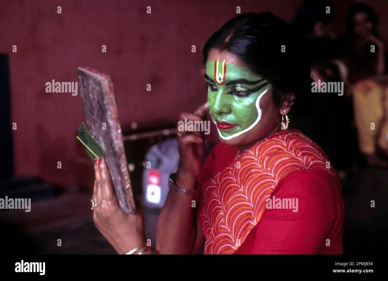 A Seethankan or Sheethankan thullal artist applying makeup in Kerala ...