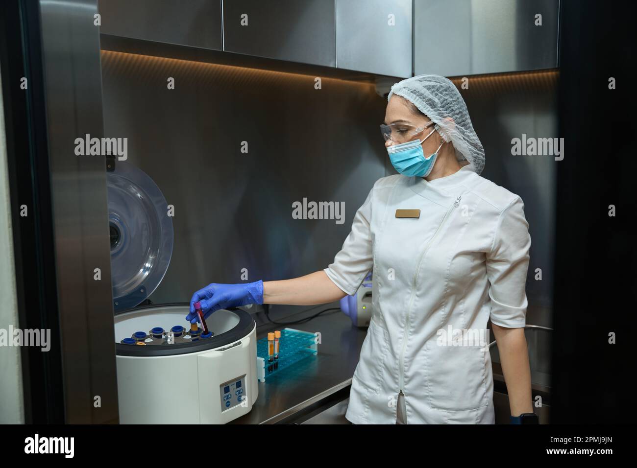 Woman laboratory assistant with a test tube with blood in it and a ...