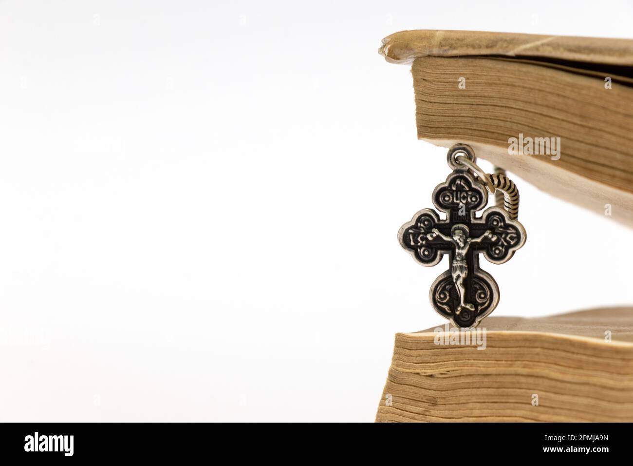 silver christian cross and old book on a white background Stock Photo ...
