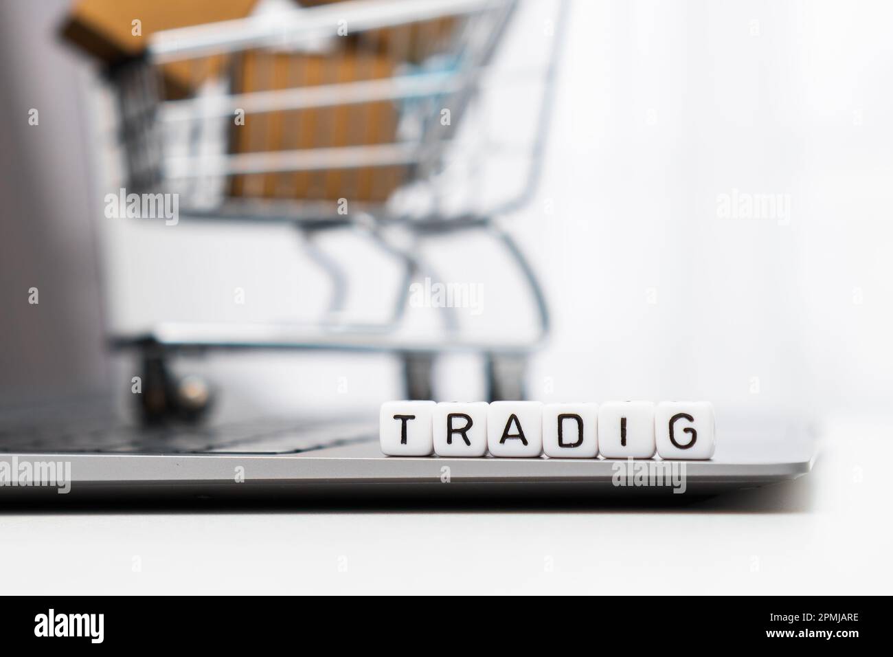 Trading words on cubes laying on the laptop and a toy shopping cart ...