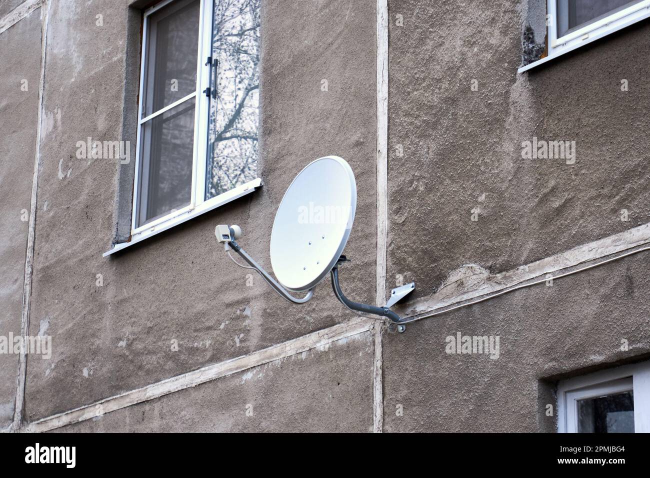 Satellite TV dish on the wall of a house Stock Photo - Alamy