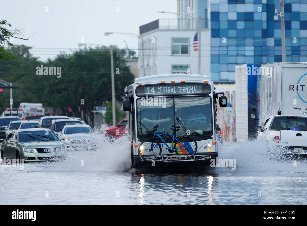 A city bus makes its way through receding floodwaters on Avenue of the ...