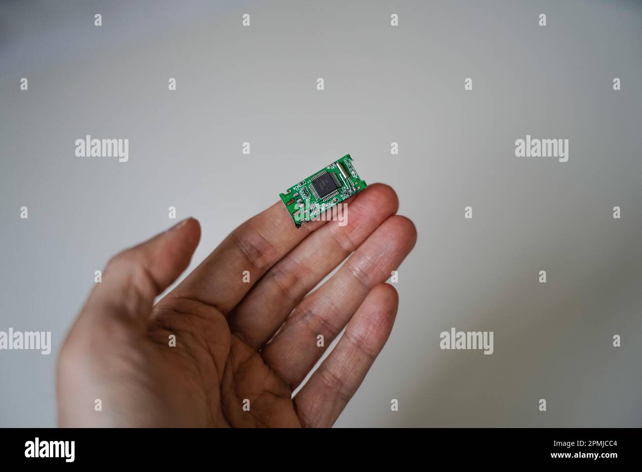 hand holding a small tiny electric microchip Stock Photo - Alamy