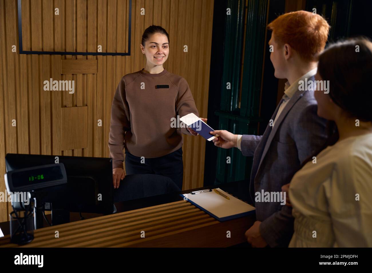 Young female administrator registers guests at the reception desk Stock ...