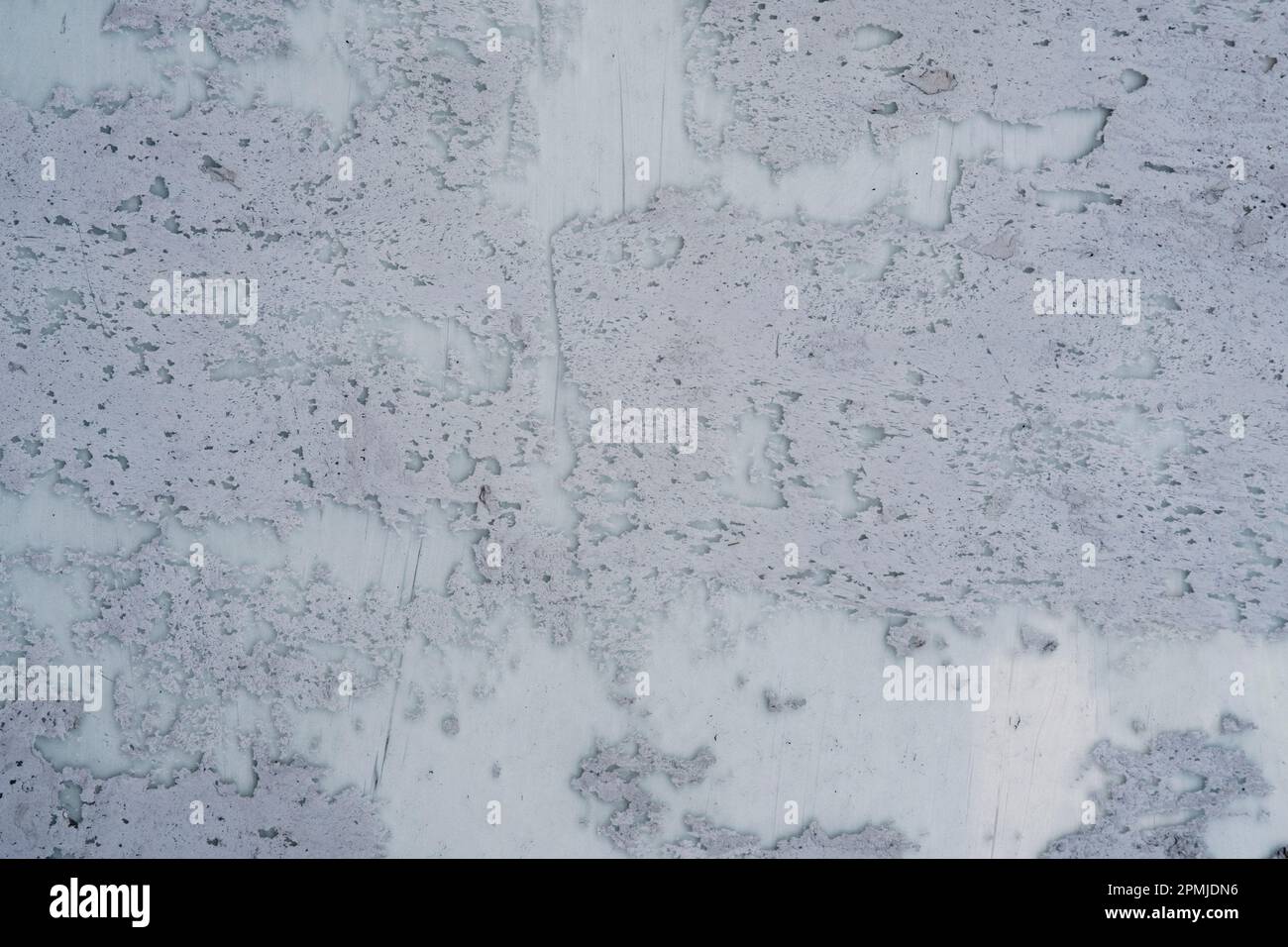 Detail of worn out plaster coating on a closed store window, grunge ...