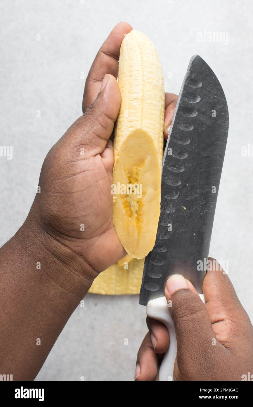 Hands slicing plantain, slicing yellow plantains for frying, process ...