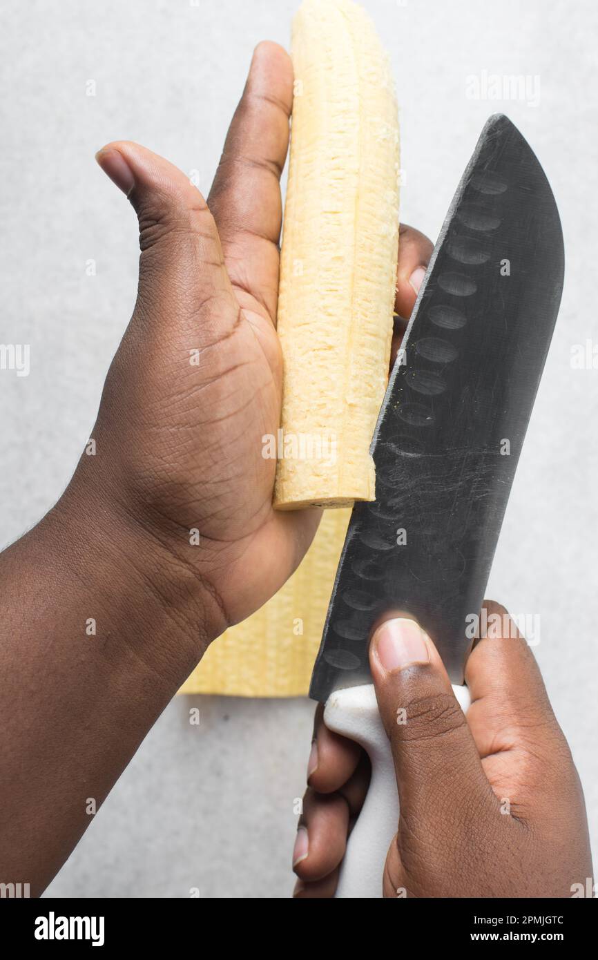 Hands slicing plantain, slicing yellow plantains for frying, process ...