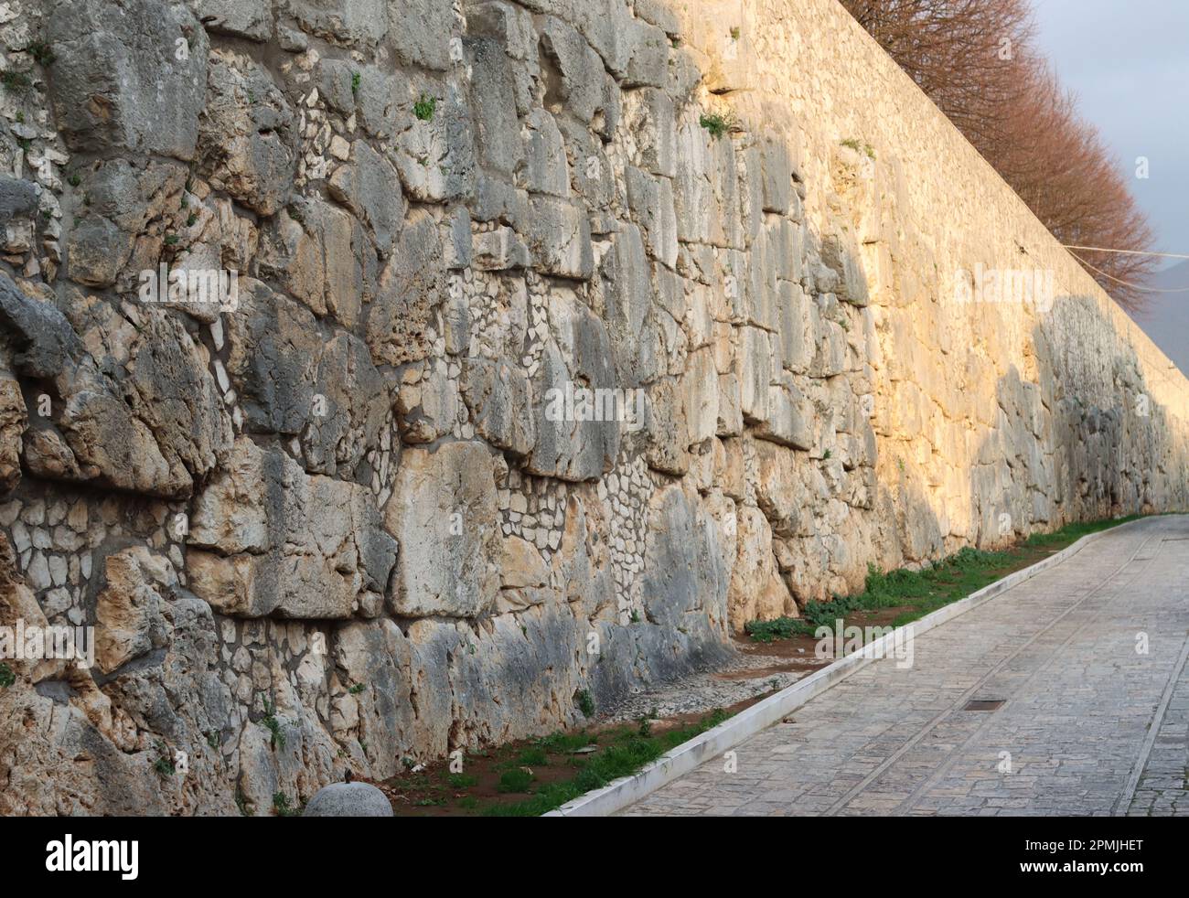 An aged stone wall along a picturesque pathway, leading to an unknown ...