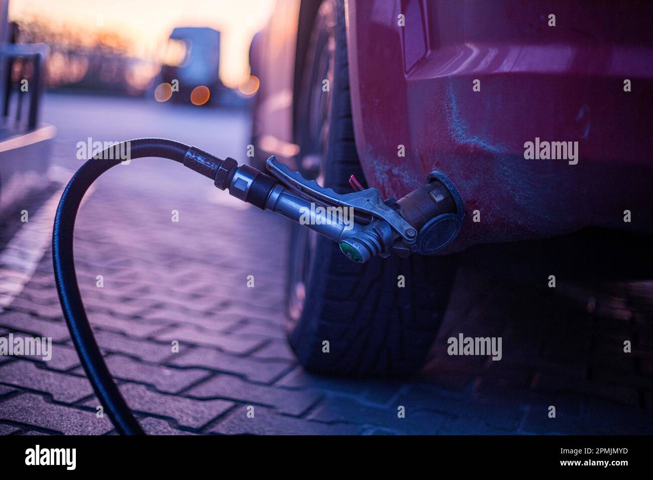 refuel a red car at a gas station at sunset, economics Stock Photo - Alamy