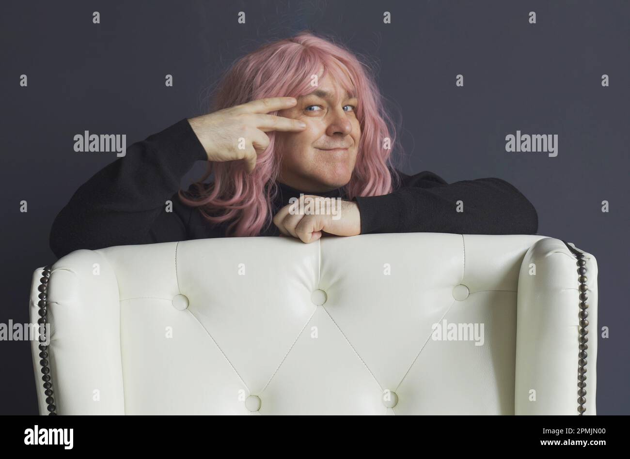Portrait of a man in a pink wig, who makes hand movements near his eyes ...