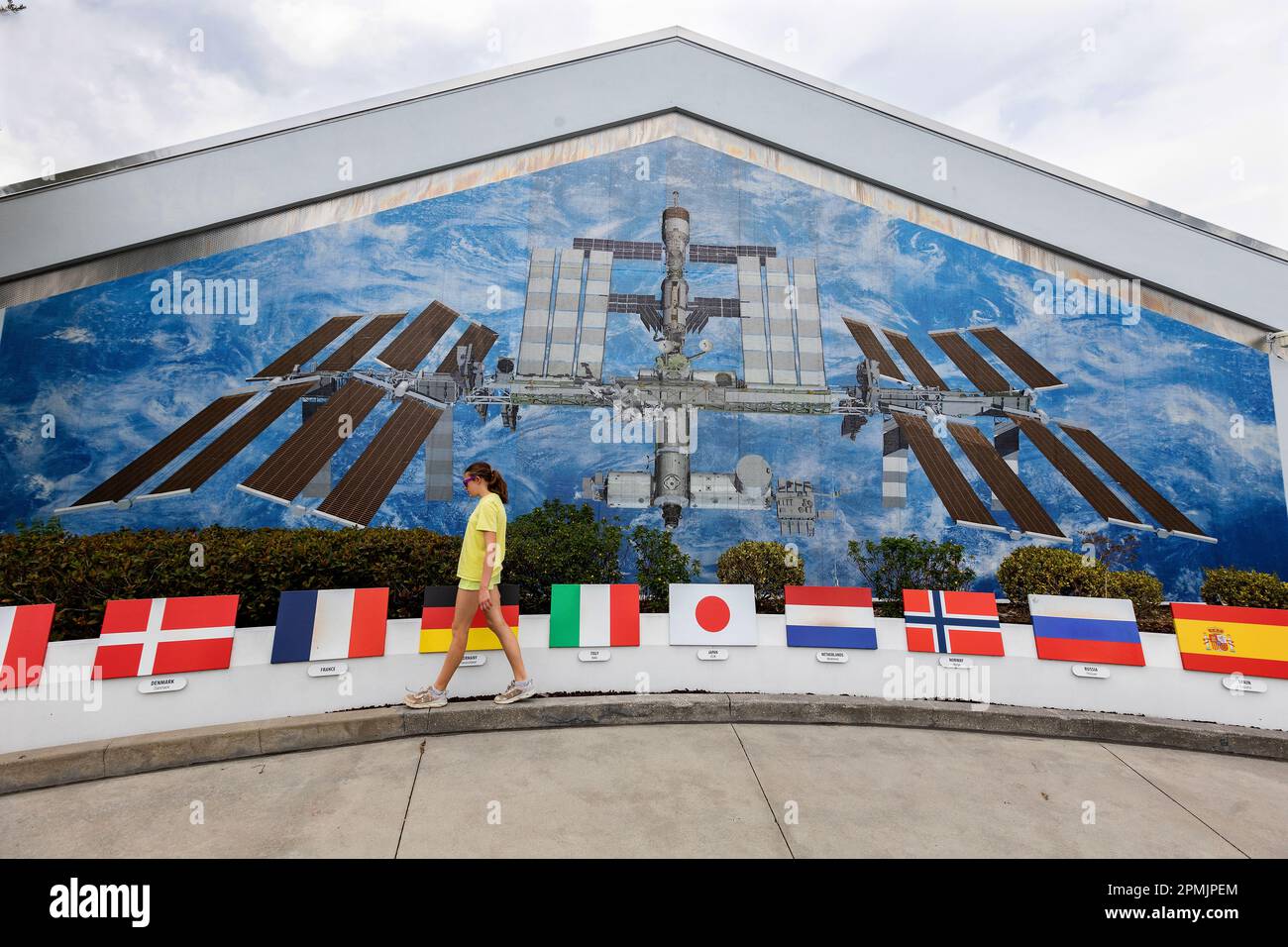 A tourist walks past the mural of the International Space Station (ISS ...