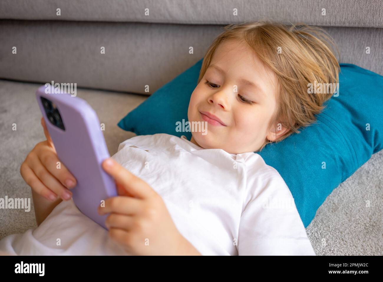 Close up cute little boy using smartphone, looking at screen, curious ...