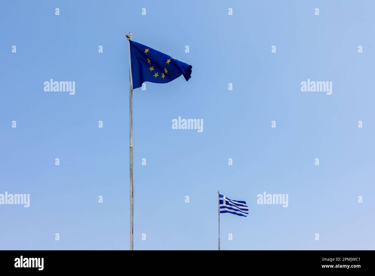 European Union EU and Greece flags is flying in air on blue sky ...