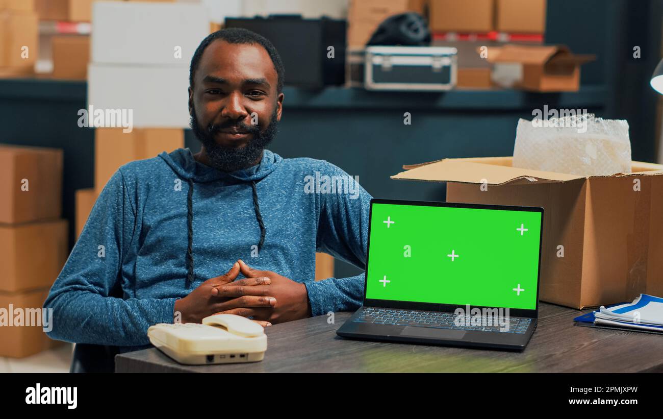 Male entrepreneur smiling and working with greenscreen on display ...