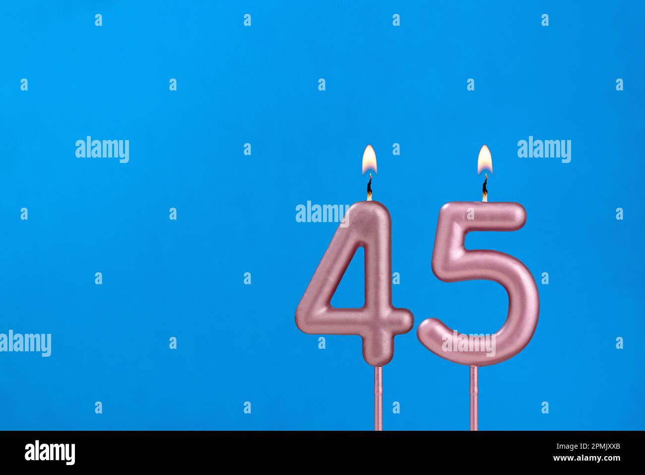 Number 45 - Burning anniversary candle on blue foamy background Stock ...