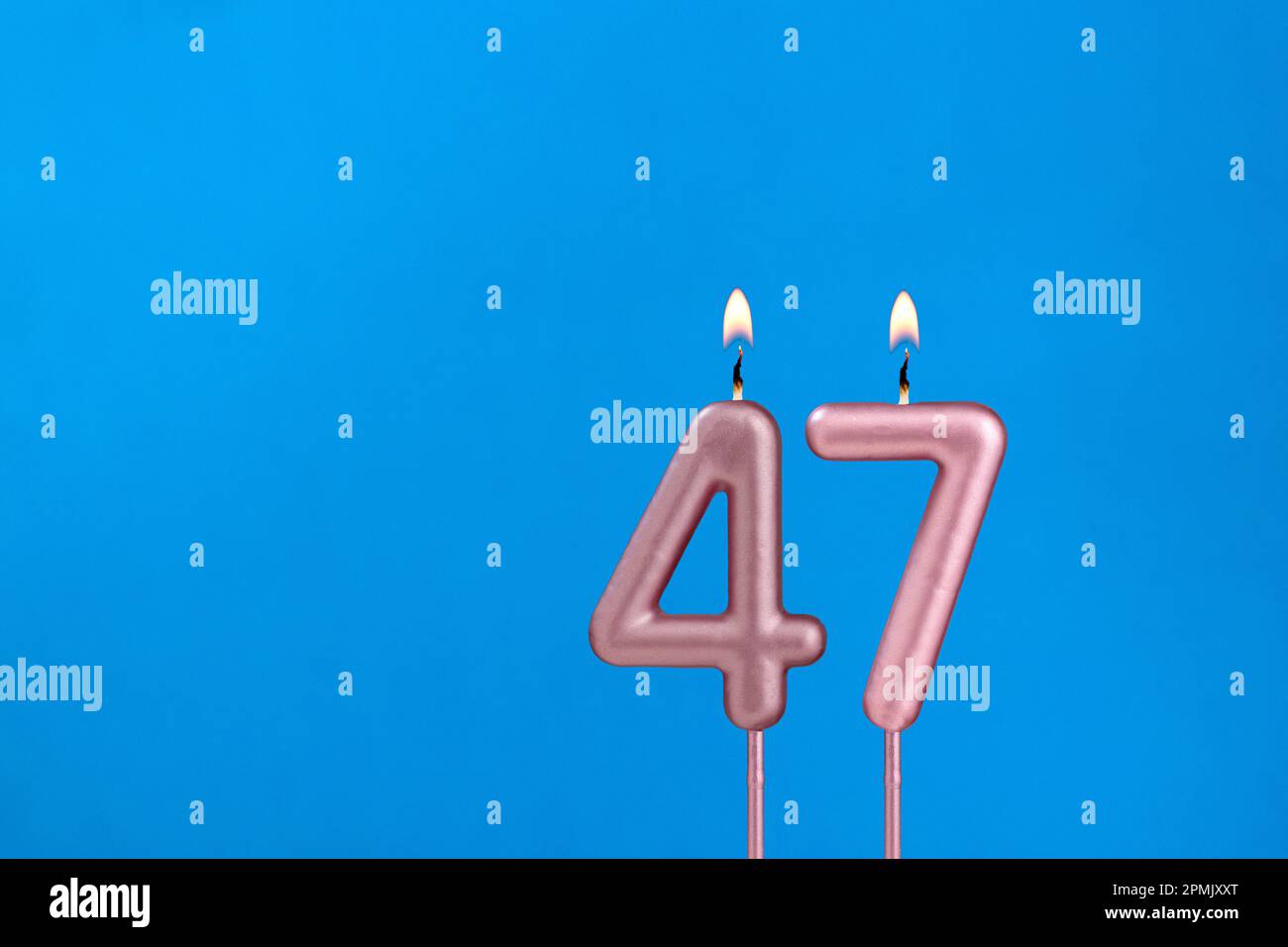 Number 47 - Burning anniversary candle on blue foamy background Stock ...