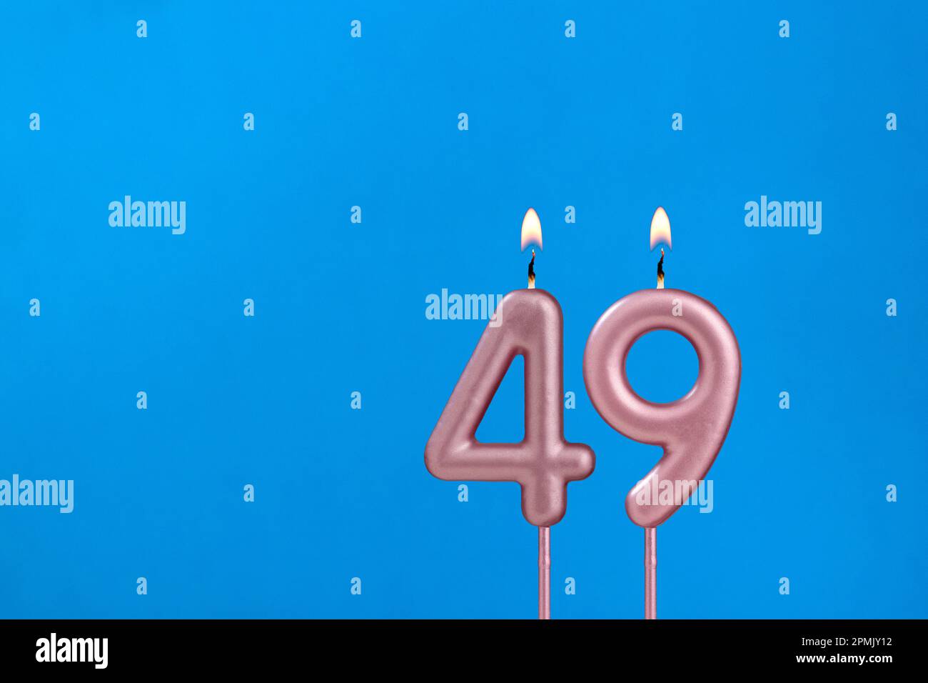 Number 49 - Burning anniversary candle on blue foamy background Stock ...
