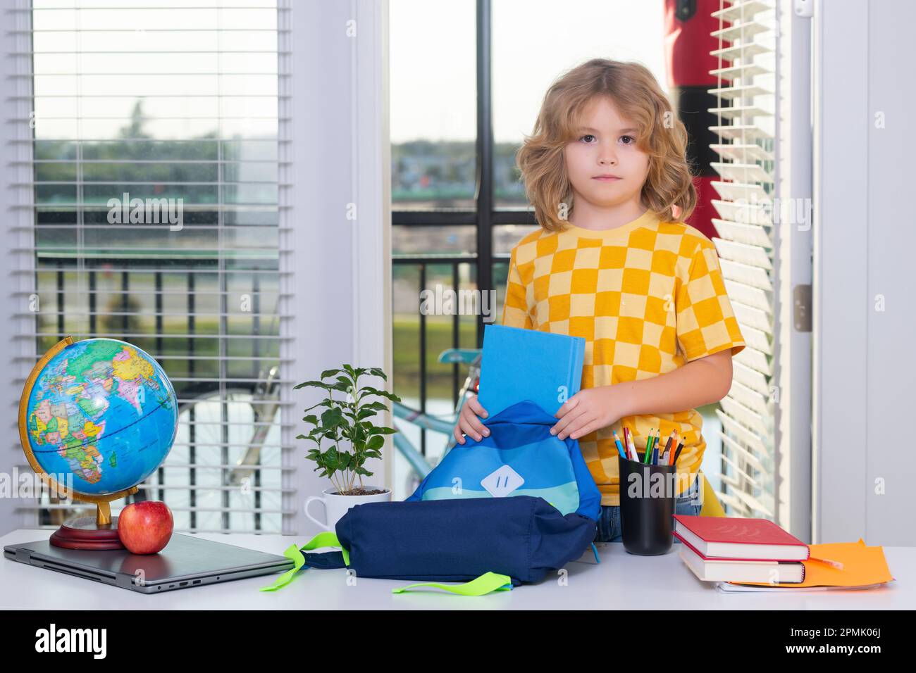 Smart caucasian school boy kid pupil student puts school supplies in a ...