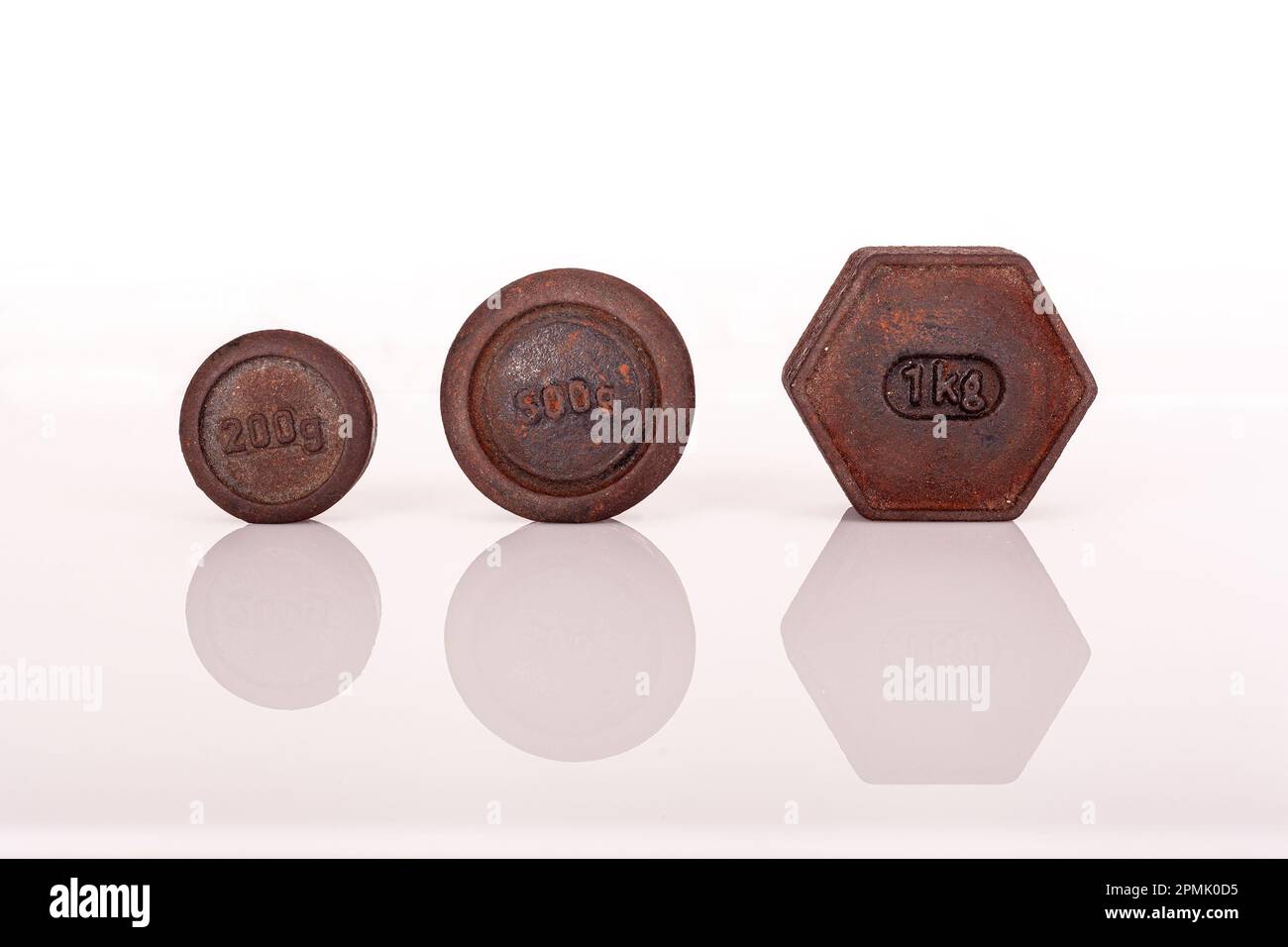 Close up of three rusty standard metric weights made of iron for ...