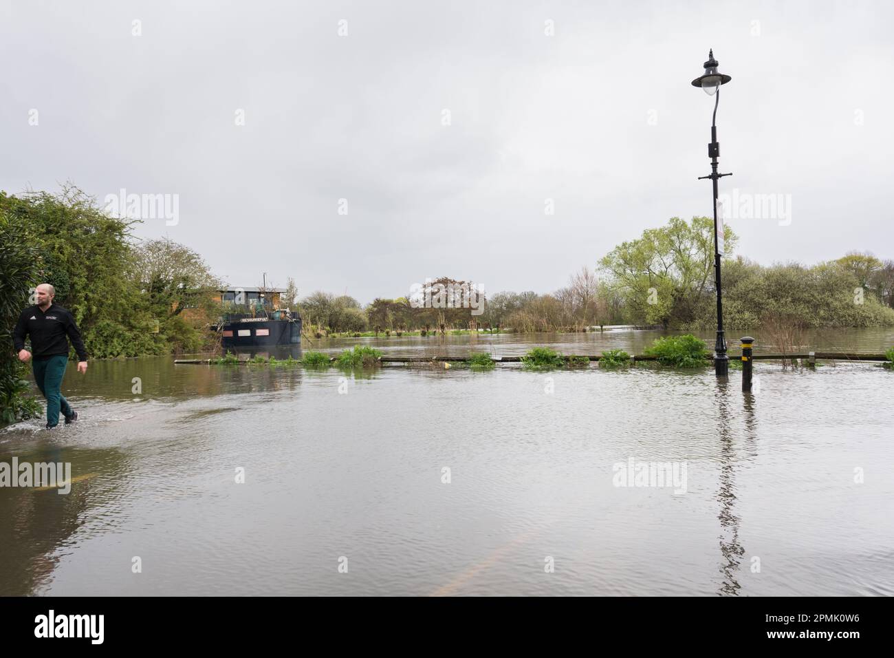A man wading through high tide floodwater on Chiswick Mall in Chiswick ...